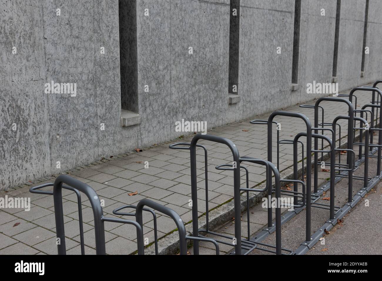 Long row of empty bike racks next to sidewalk near closed public school ...
