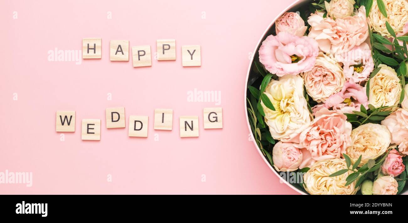 Happy wedding lettering on the wooden squares with letters on the pink ...
