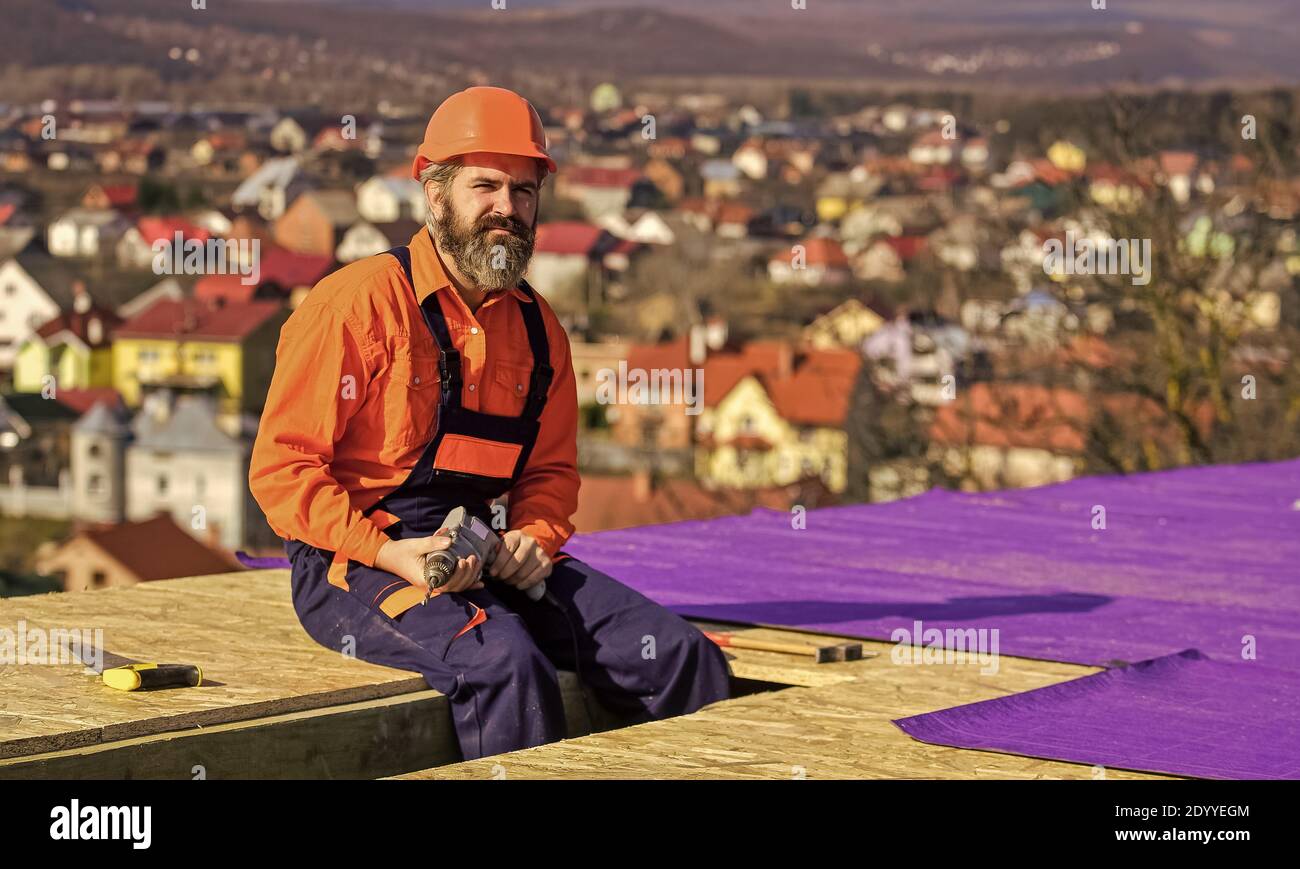 roofer working on roof structure of building on construction site ...