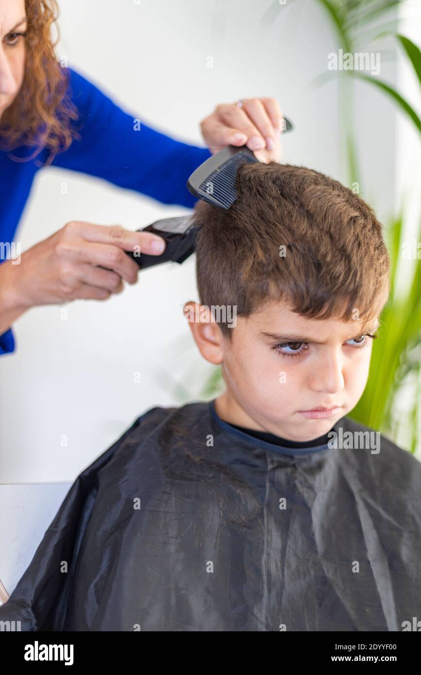 Angry boy getting haircut at home Stock Photo - Alamy