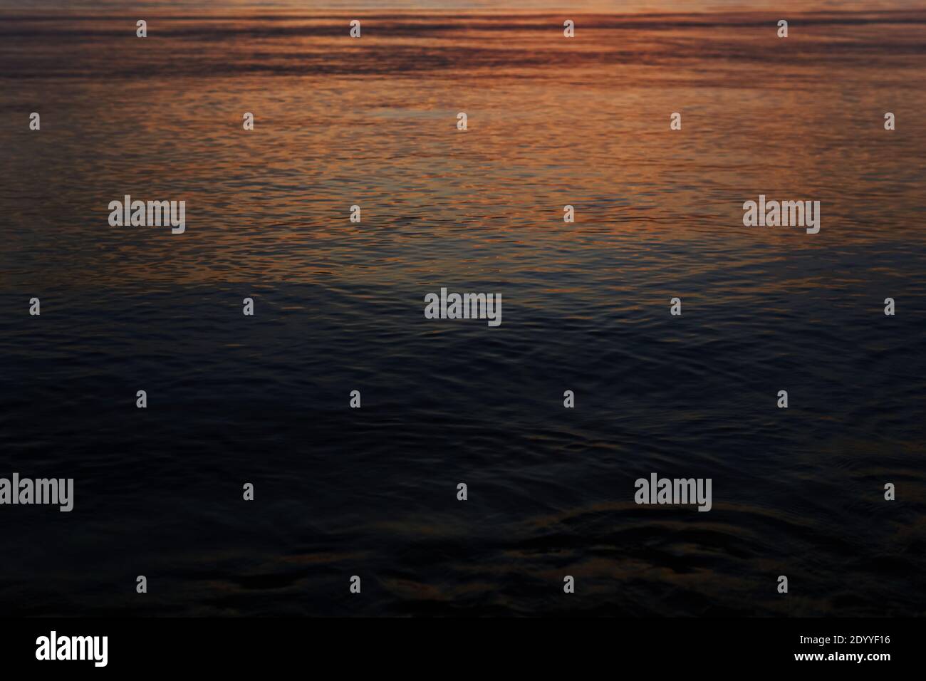 dark water surface with a reflection of a distant dawn Stock Photo - Alamy