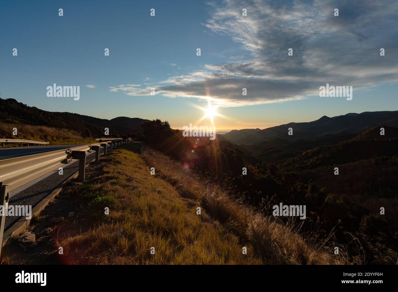 Shiny sun rising on a winter nature landscape on a blue sky at the edge ...