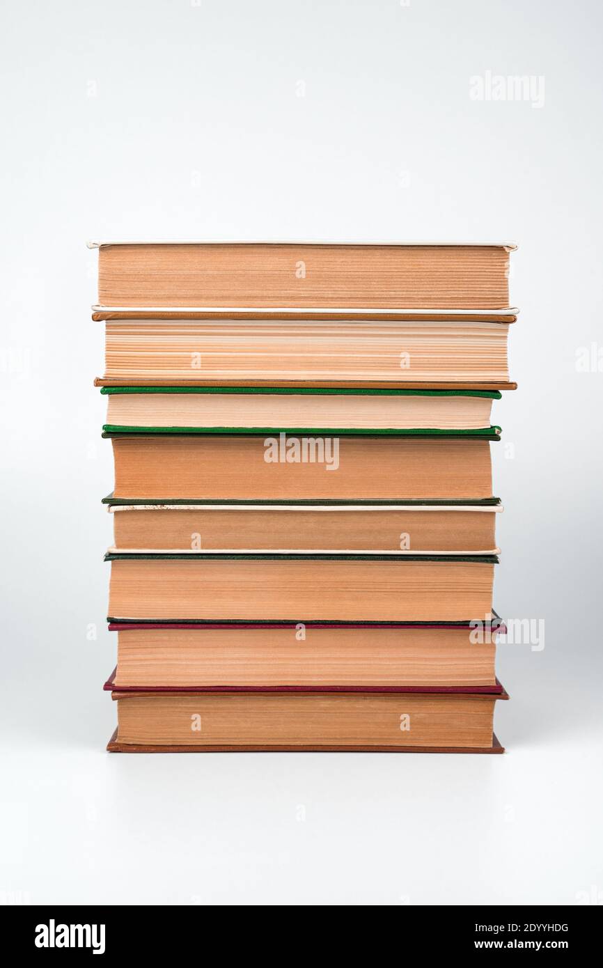 A stack of books on a white background. Side view Stock Photo - Alamy