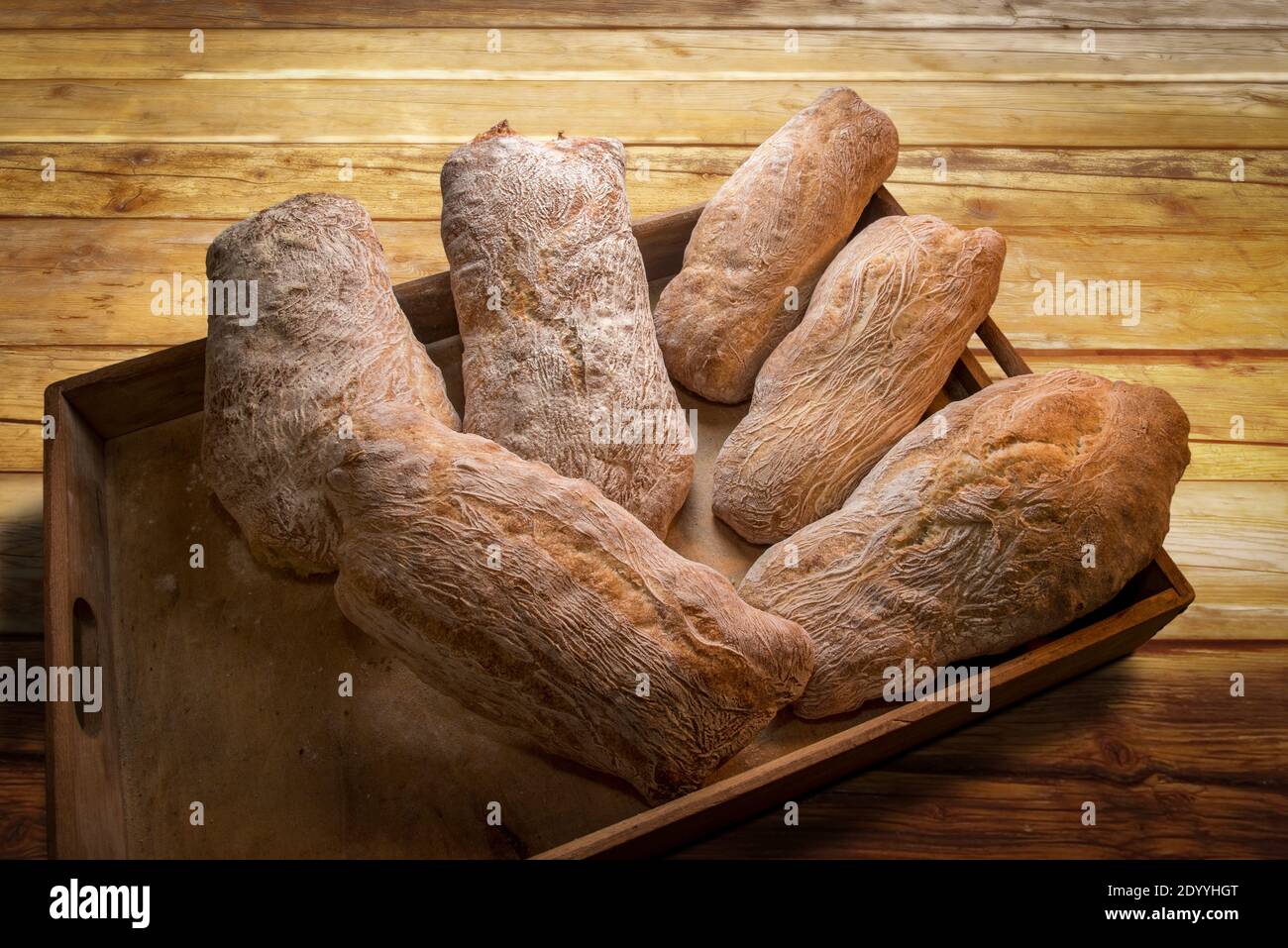 Italian ciabatta bread, six loaves in wooden tray on rustic wooden ...