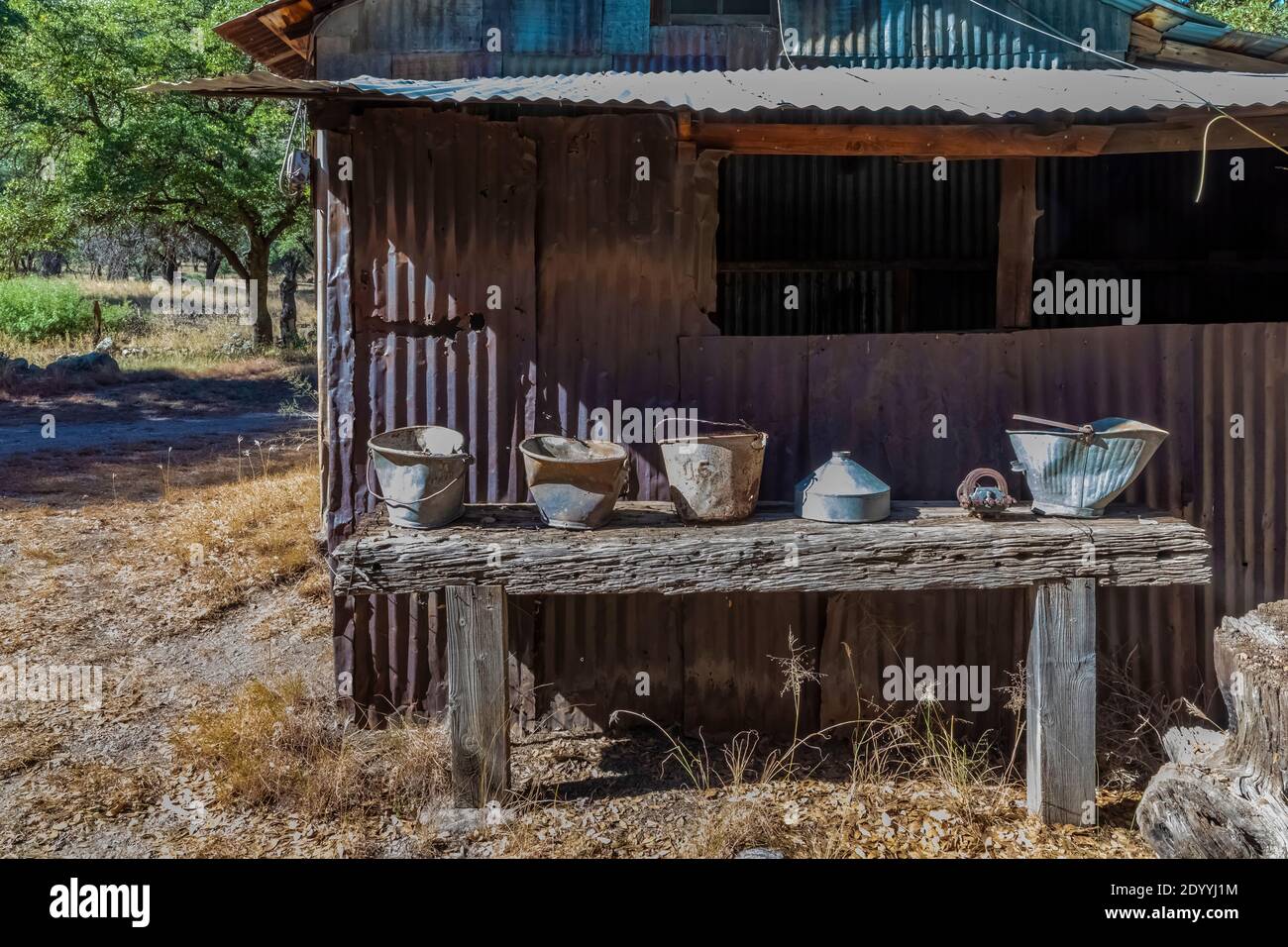 Old buckets on bench and corrugated metal barn at Faraway Ranch in ...