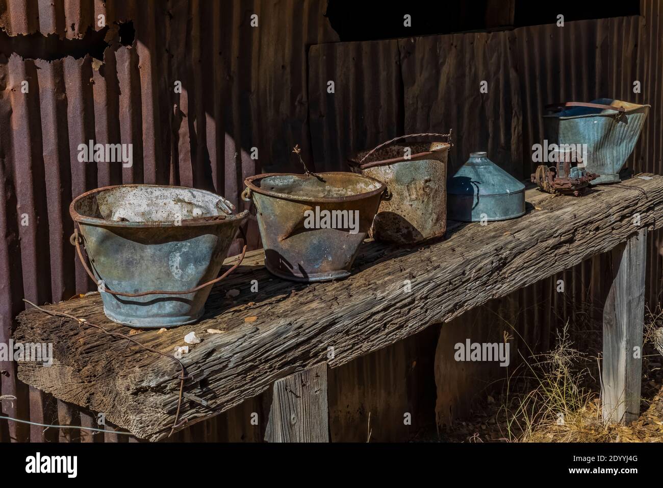 Old buckets on bench and corrugated metal barn at Faraway Ranch in ...