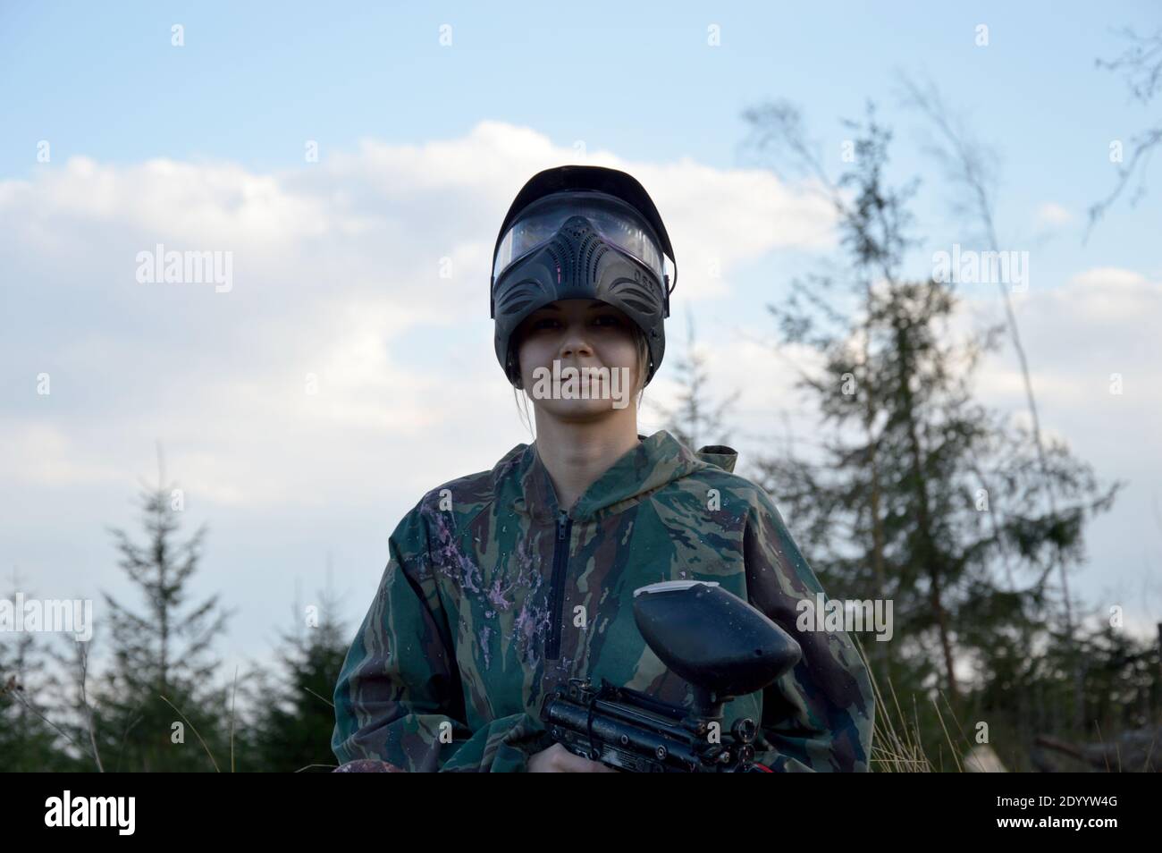 Paintball sport player girl in protective camouflage uniform and mask ...