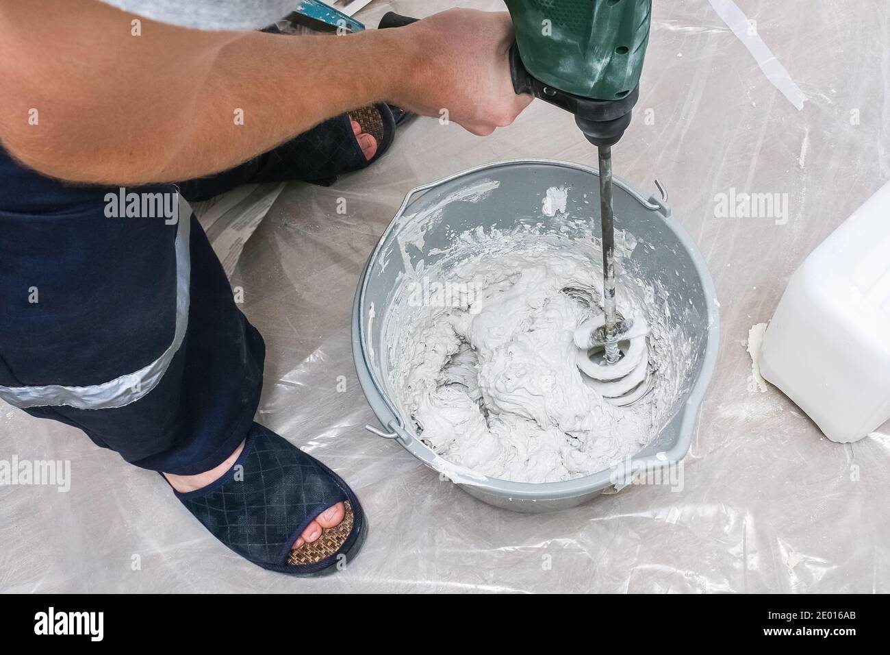 A male worker spreads the putty mixture and flattens the wall Stock ...
