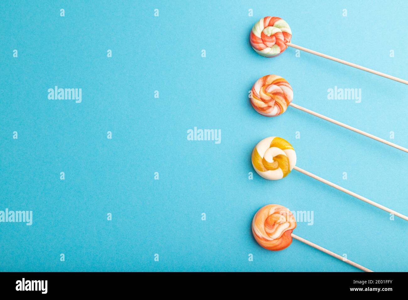 Four lollipop candies on blue pastel background. copy space, top view ...