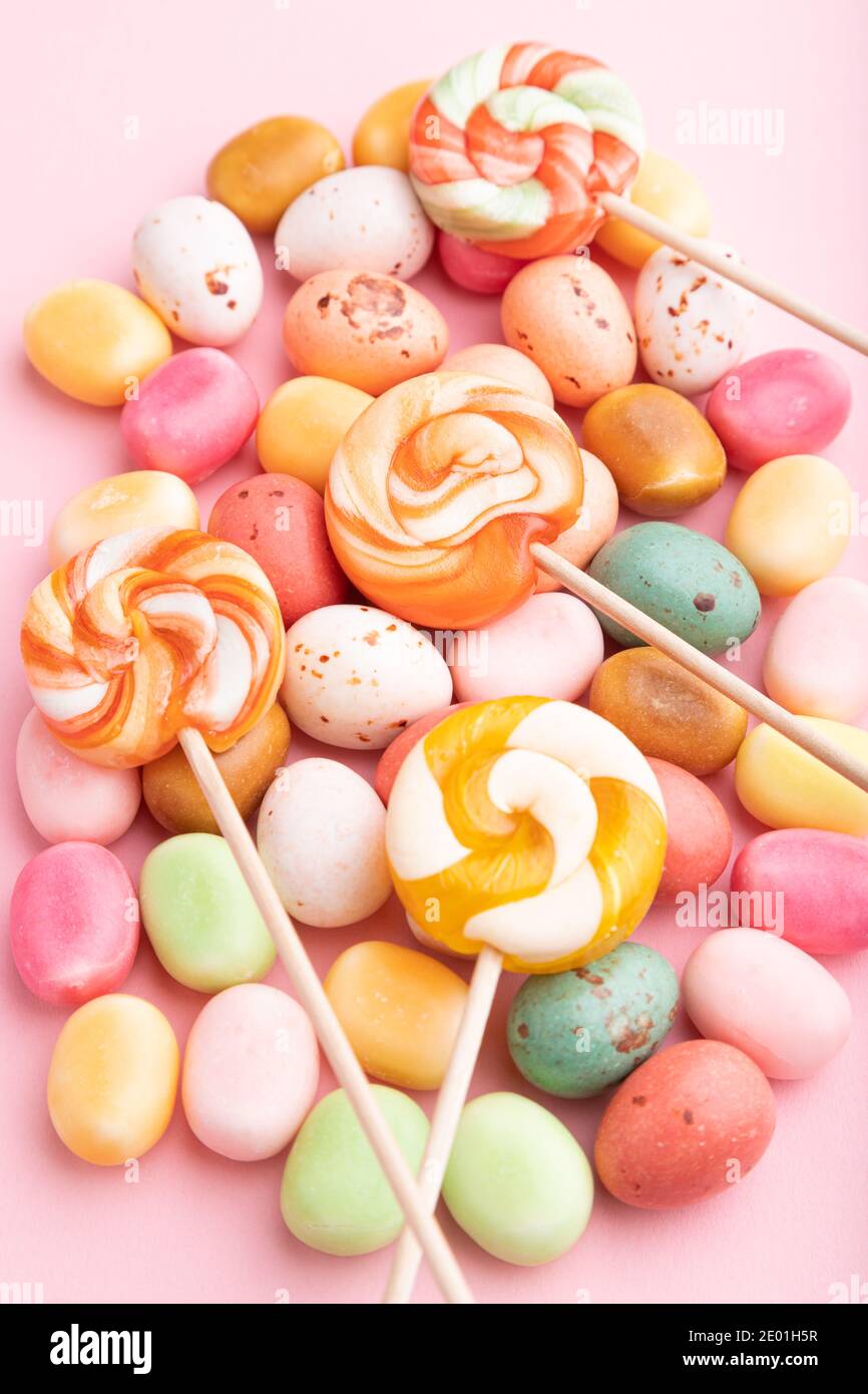 Various caramel candies on pink pastel background. close up, side view ...