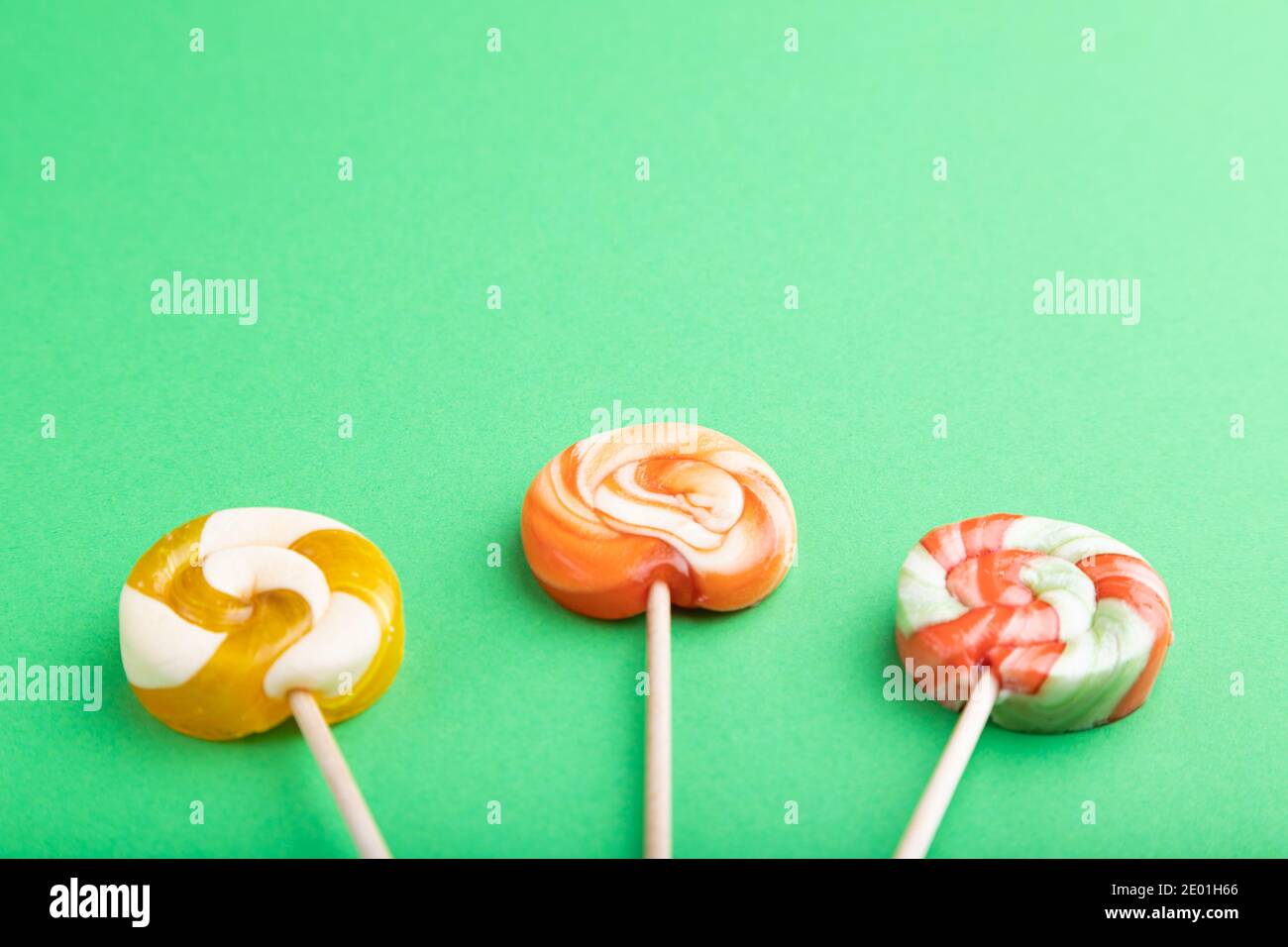 Three lollipop candies on green pastel background. copy space, top view ...