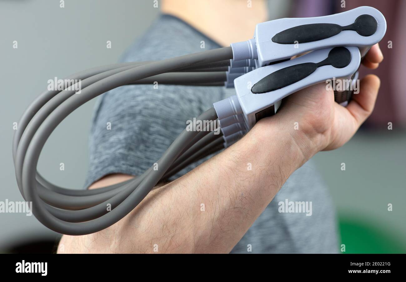 The man is holding an expander on his shoulder. Finished fitness ...