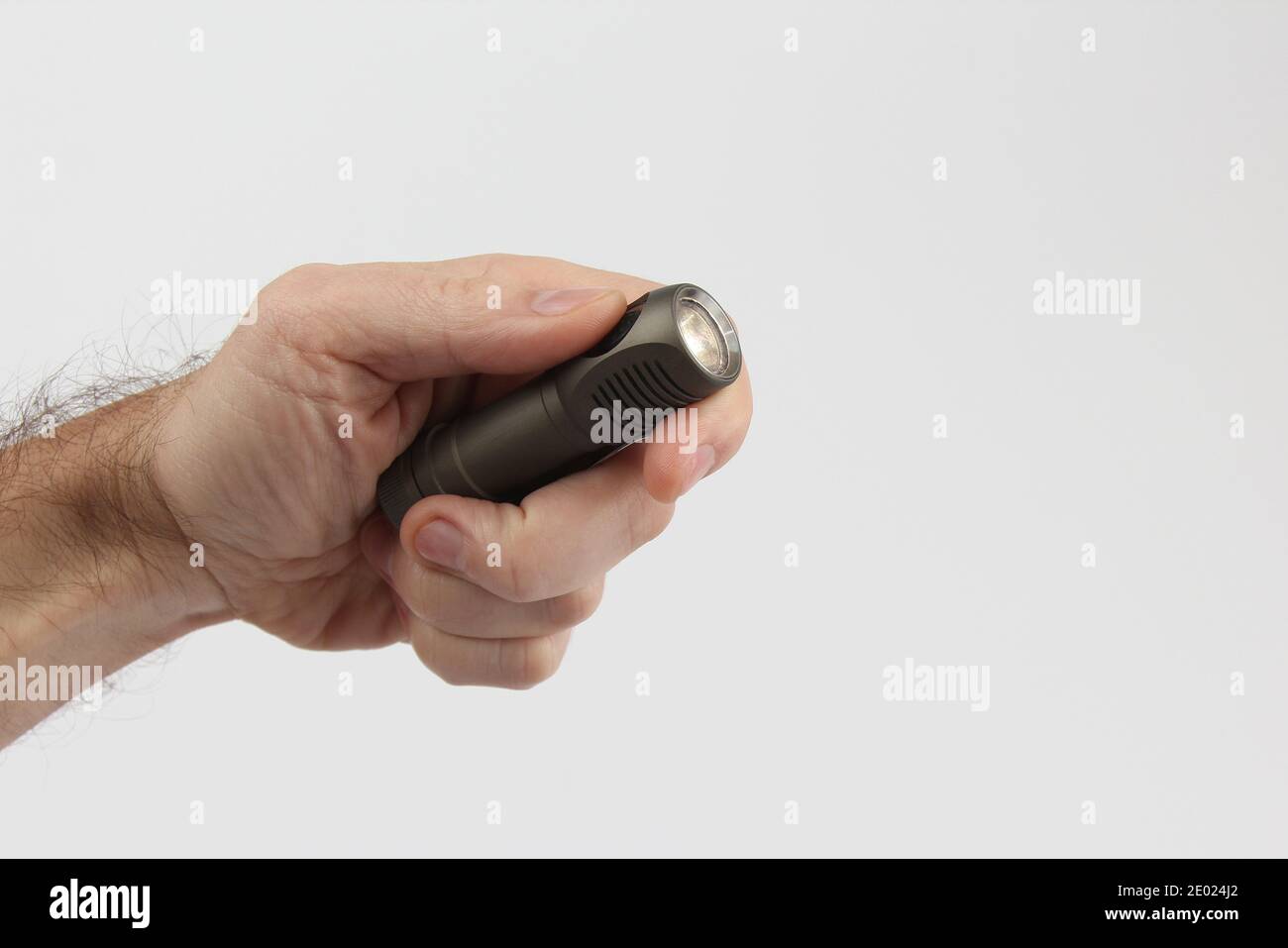 the hand holds included a small flashlight on a white background Stock ...