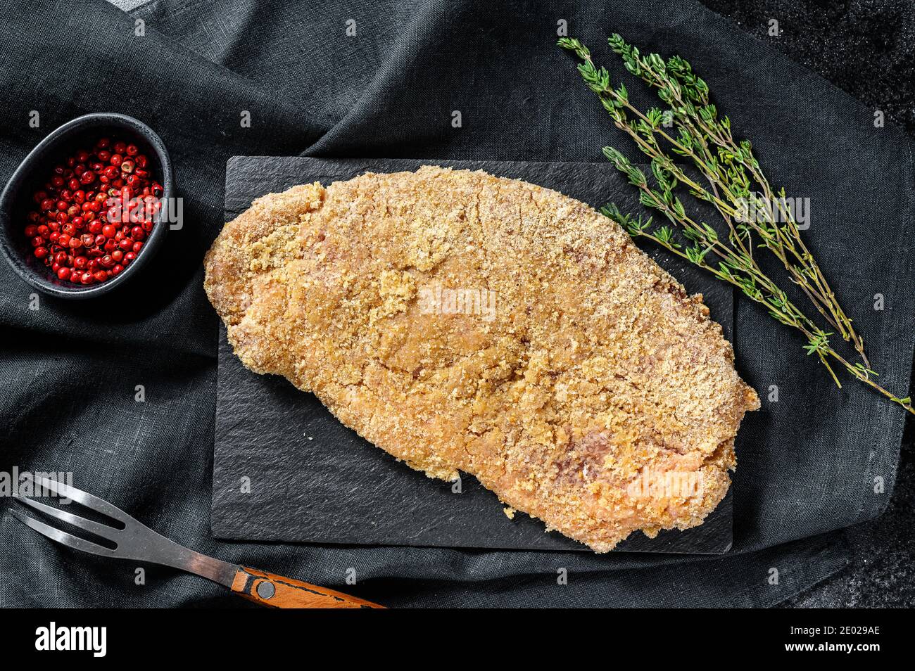 Homemade raw breaded German Weiner Schnitzel. Black background. Top ...