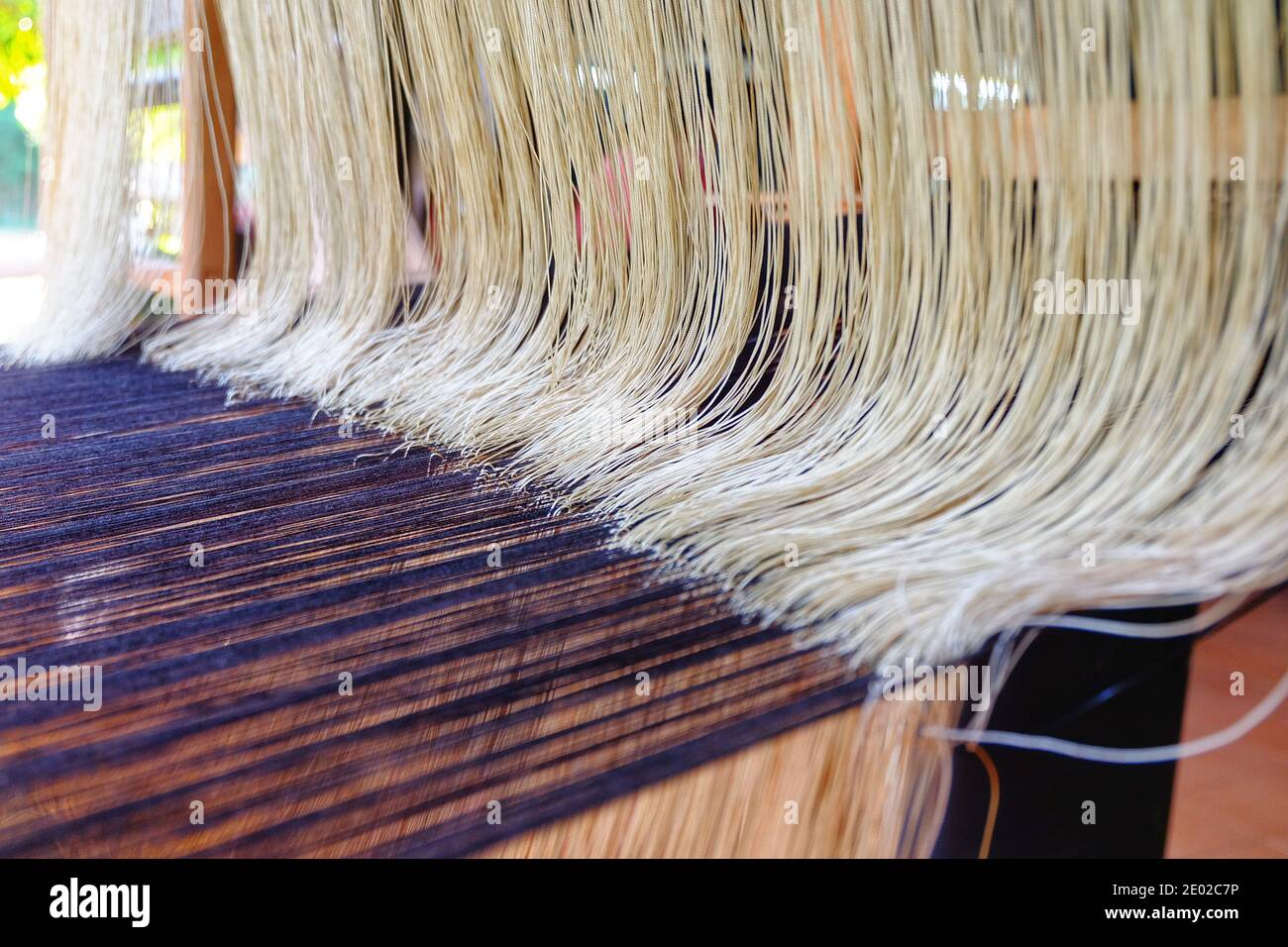 Traditional weaving loom with colorful cotton fiber being woven into ...