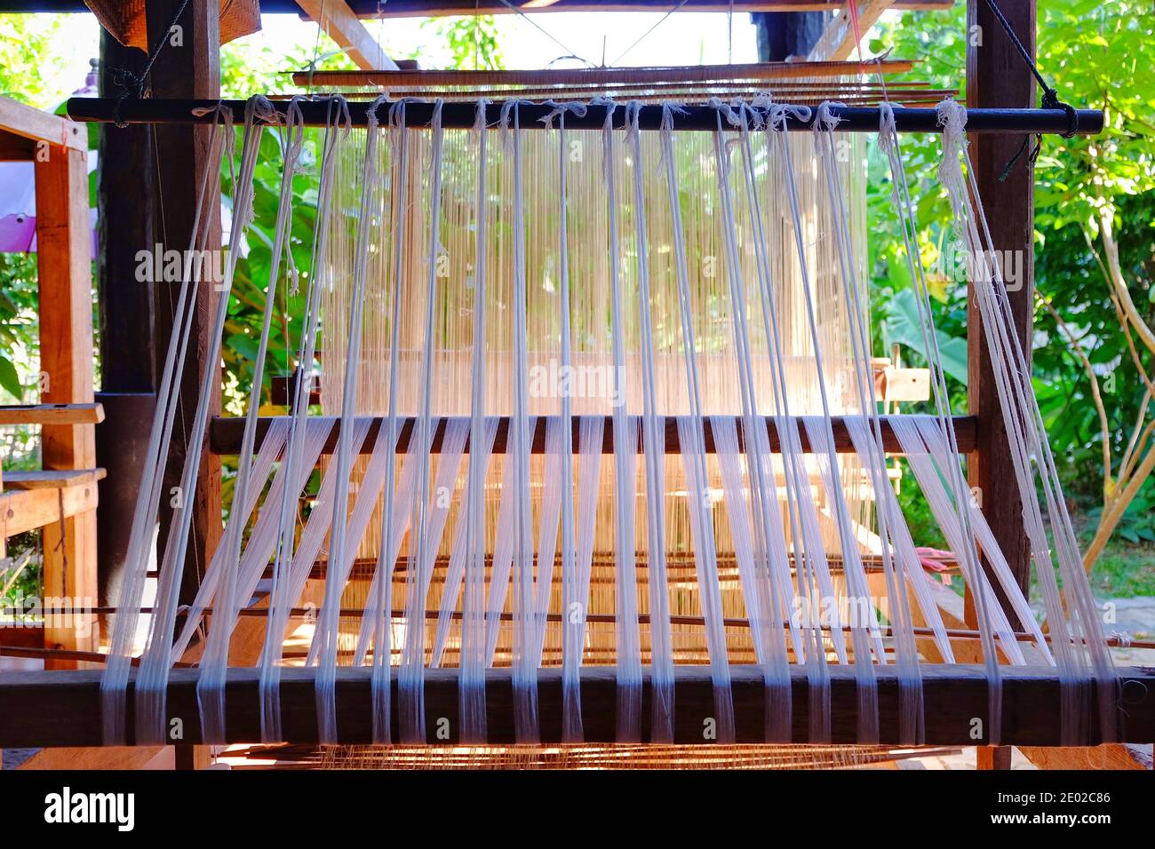 Ancient weaving loom with cotton fiber being made into traditional Thai ...