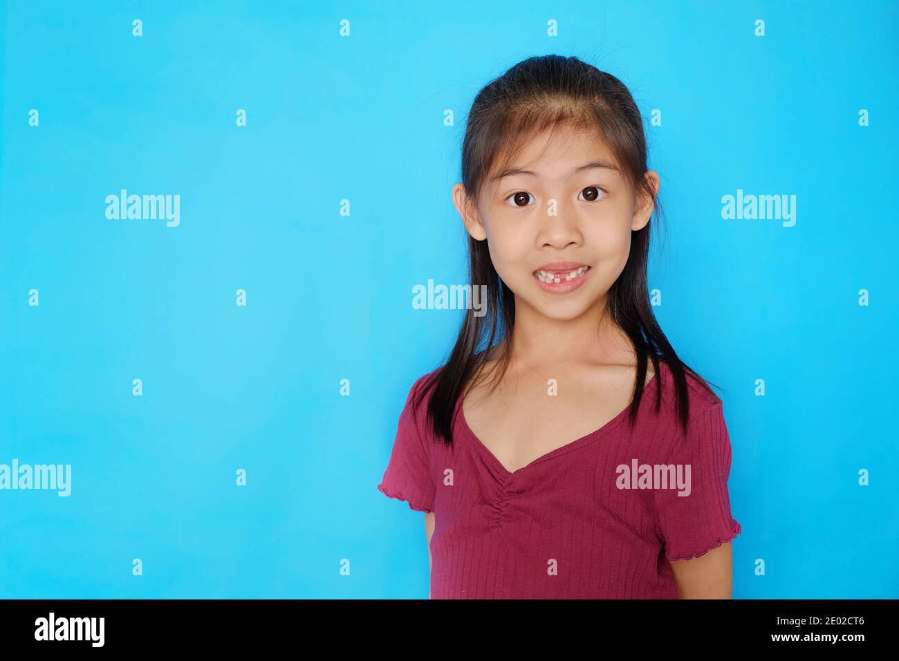 A Closeup Picture Of A Cute Asian Girl Looking Straight At The Camera Smiling Feeling Happy
