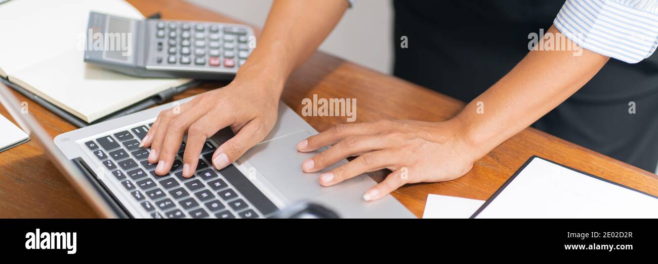hands close up Freelancer busy working on a laptop computer on desktop ...