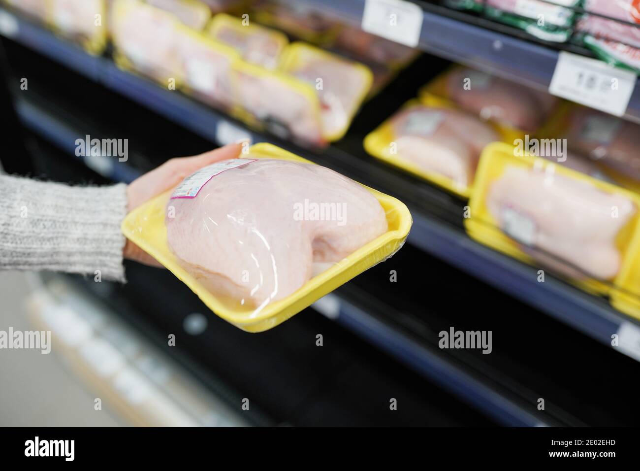 Woman choosing packed chicken meat in supermarket Stock Photo - Alamy