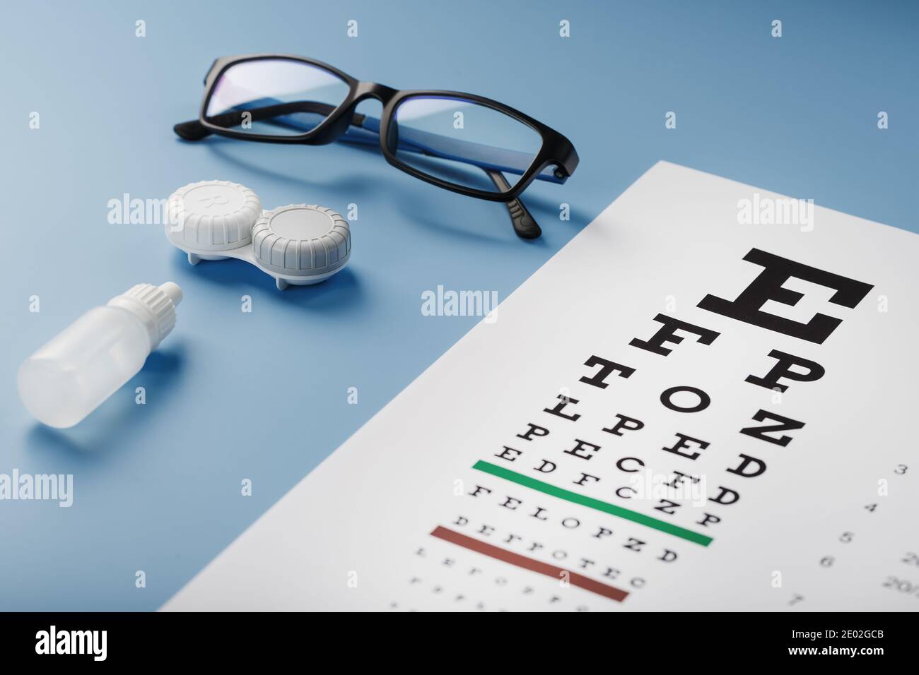 Glasses with Contact Lenses, drops and an Optometrist's Eye Test Chart ...