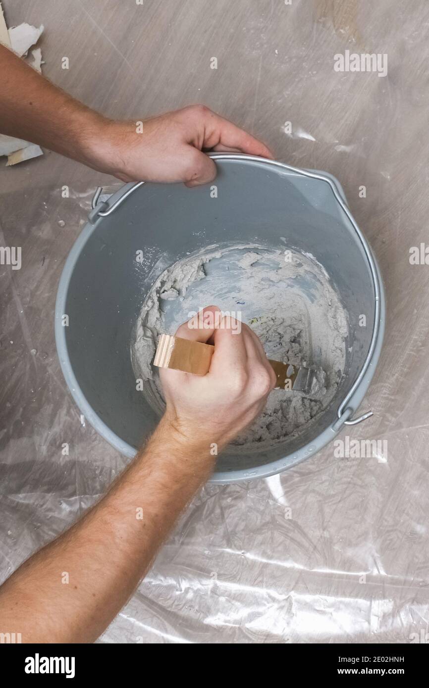 Mixing white plaster in a bucket with a stirrer. Close-up Stock Photo ...