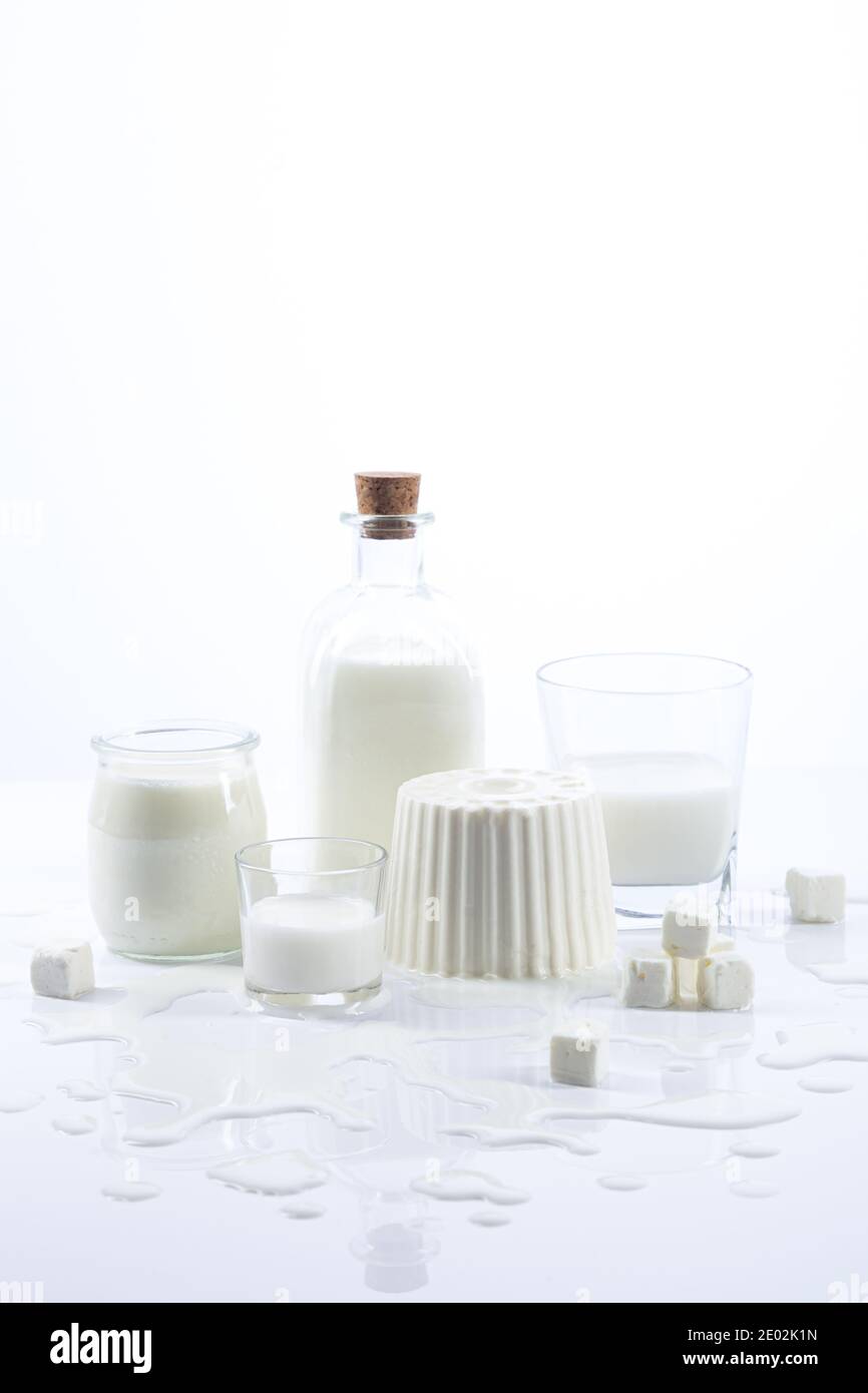 White dairy products in glass recipients on white background with copy ...