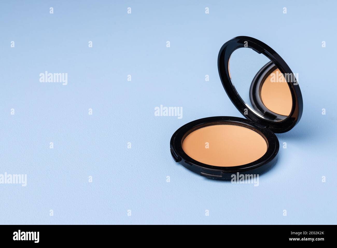 Compact face powder on blue background front view Stock Photo - Alamy