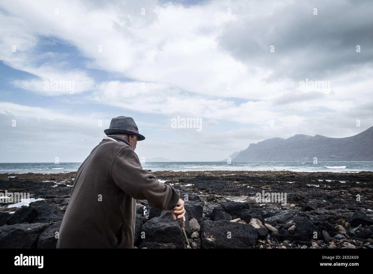 Local man walking on the beach in Lanzarote, Canary Islands. Volcanic ...