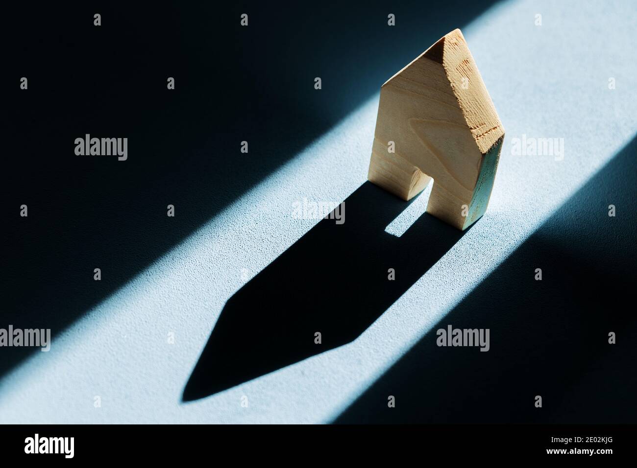 Miniature wooden house with shadows on blue background Stock Photo - Alamy