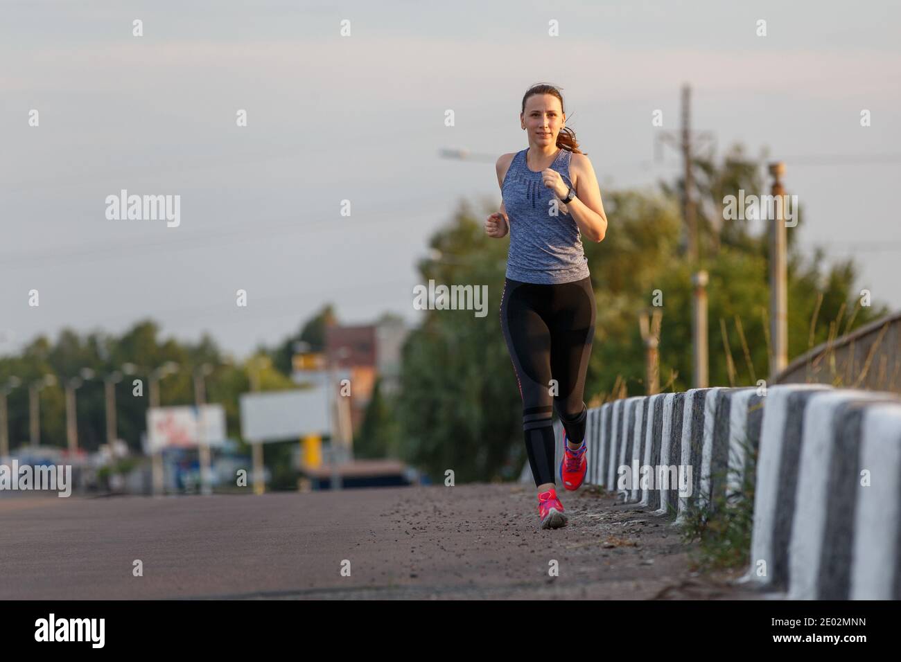 Fitness young woman running on the road in the city Stock Photo - Alamy