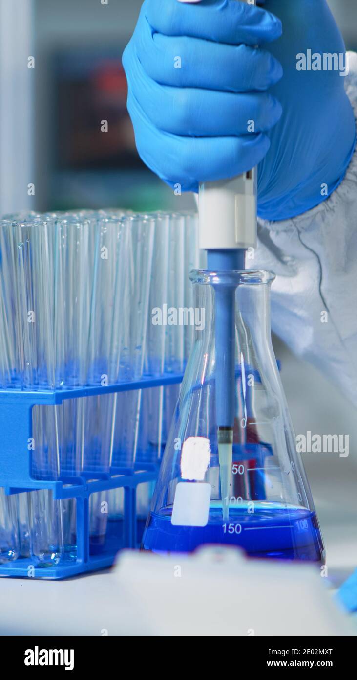 Close up of researcher testing liquid sample using micropipette for new ...