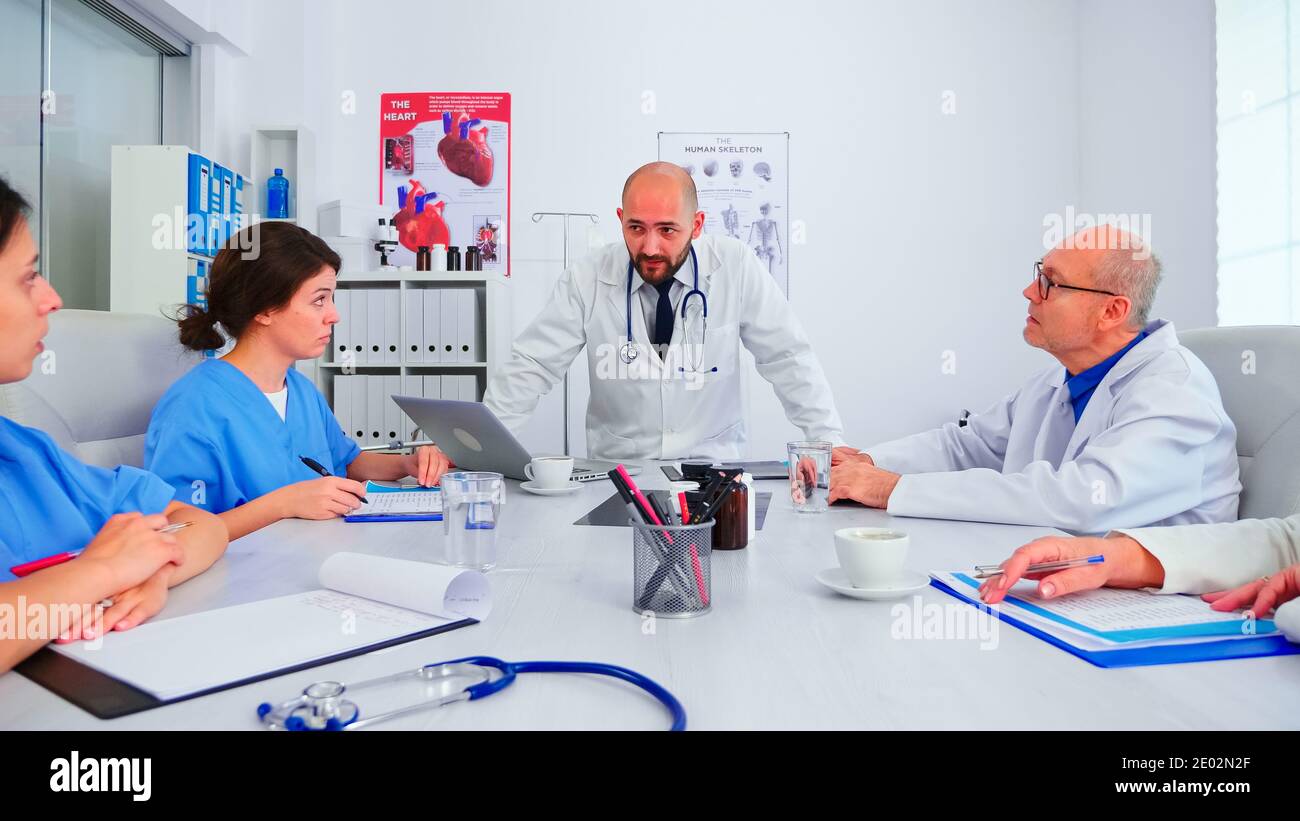 Doctor having professional discussion with medical staff in hospital ...