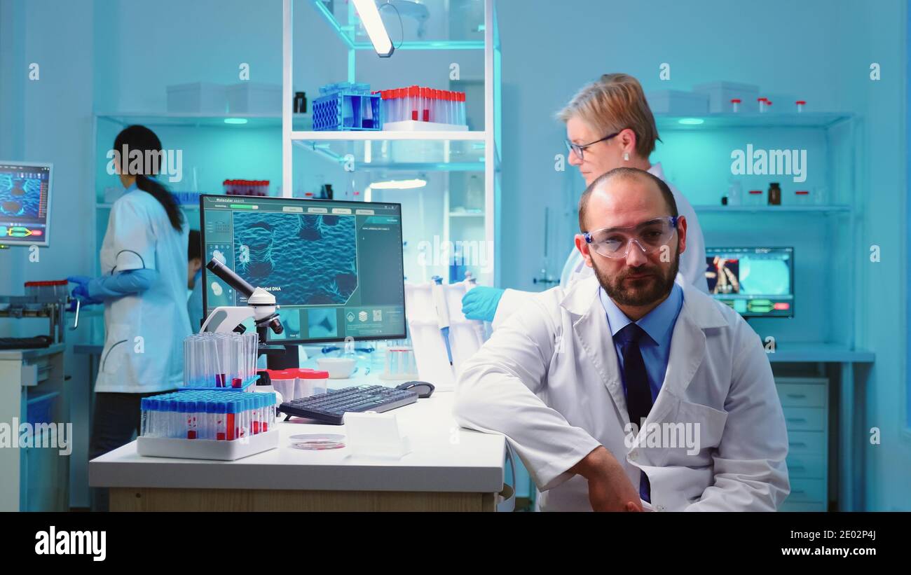 Portrait of experienced scientist man looking tired at camera working ...