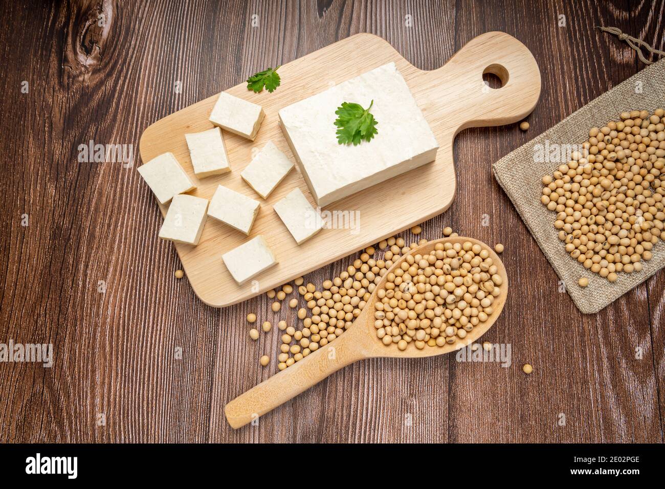Whole fresh tofu and Diced Tofu on wood cutting board with soy bean in ...