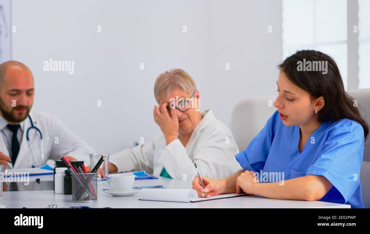 Team of doctors having medical conference dividing their tasks ...