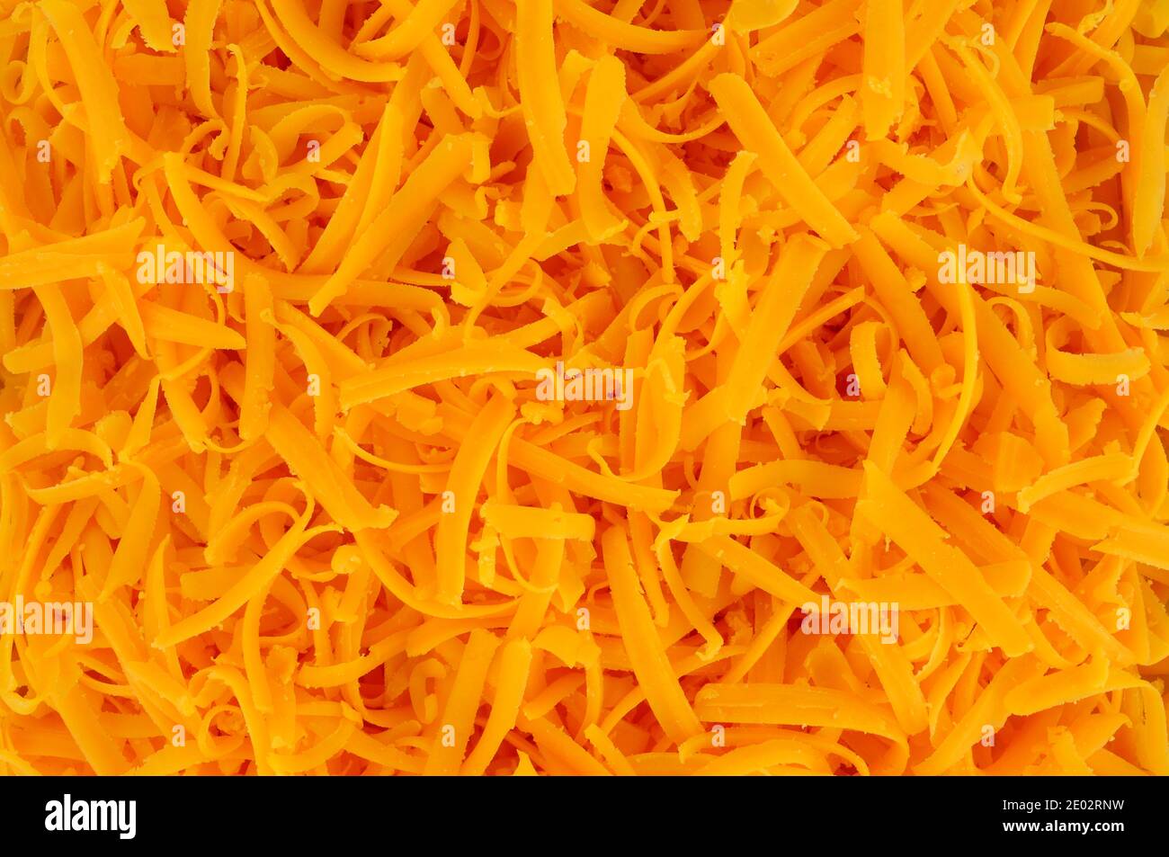 Grated cheddar cheese background texture Stock Photo - Alamy