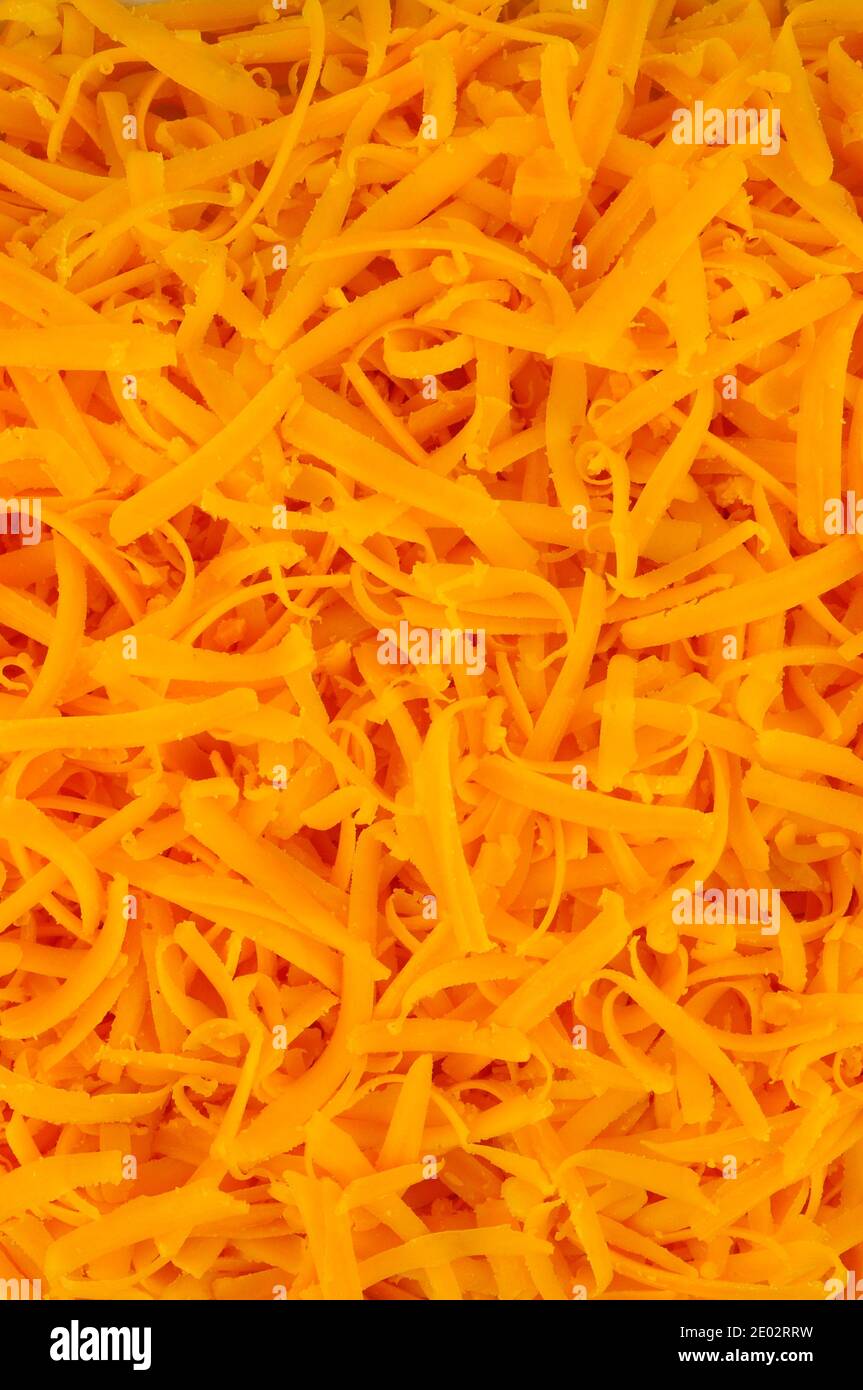 Grated cheddar cheese background texture Stock Photo - Alamy