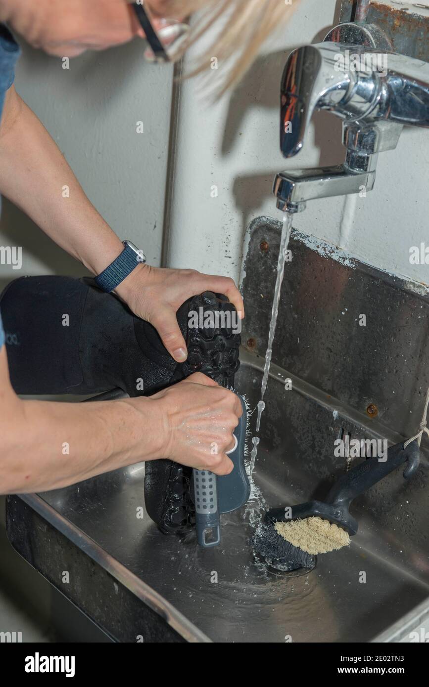 Cleaning and checking boots for seeds and mud prior to landing on South ...