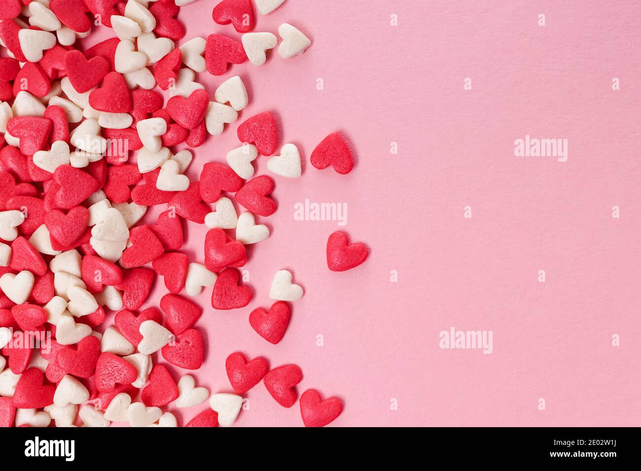 Sugar heart shaped sprinkles on pastel pink background Stock Photo - Alamy