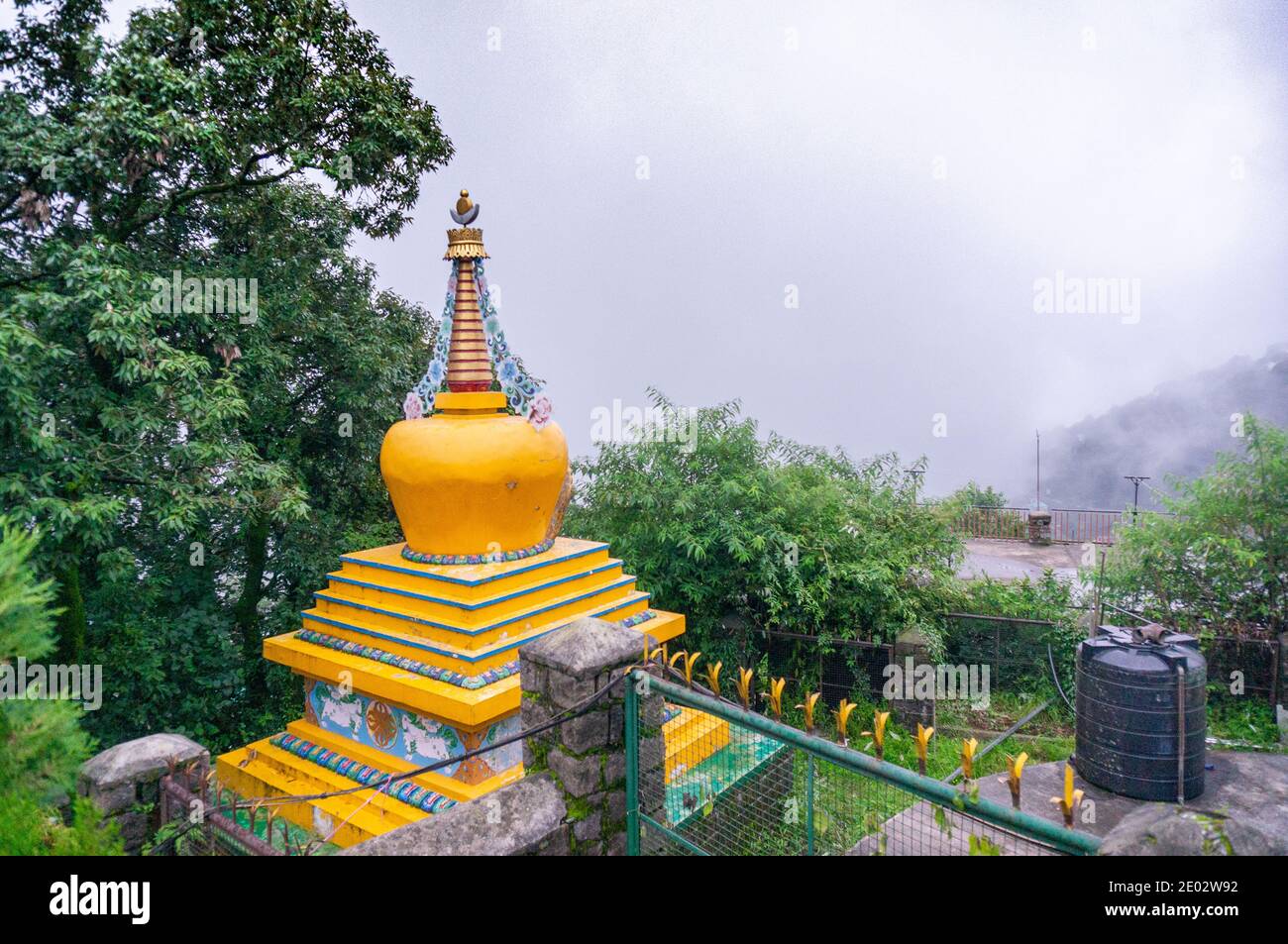 Yellow temple spire dome building perched in the middle of trees ...