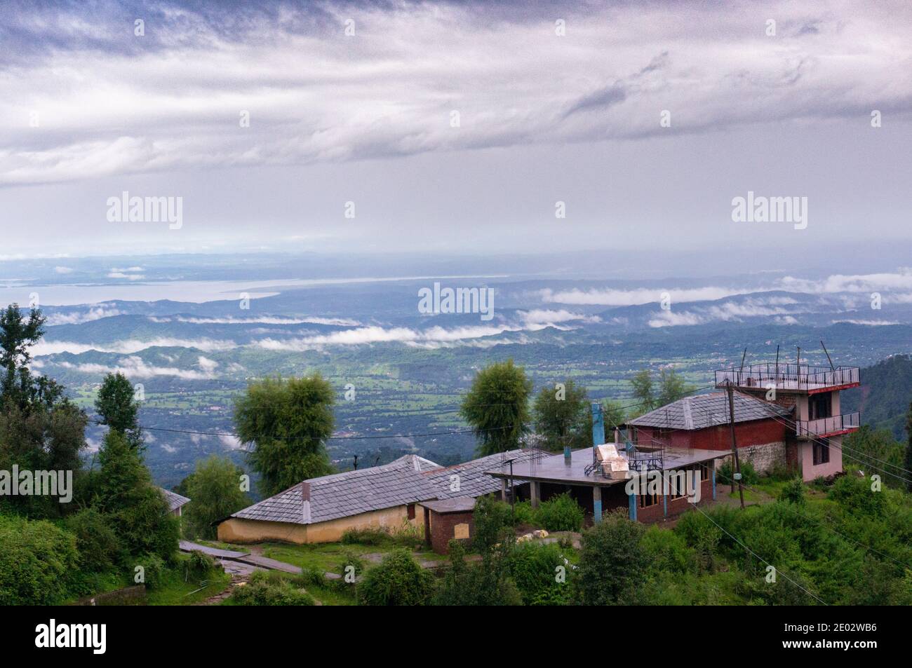 building perched on the edge of a mountain with trees all around ...