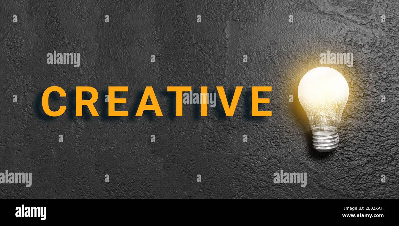 Illuminated light bulb with creative text on dark grunge background ...