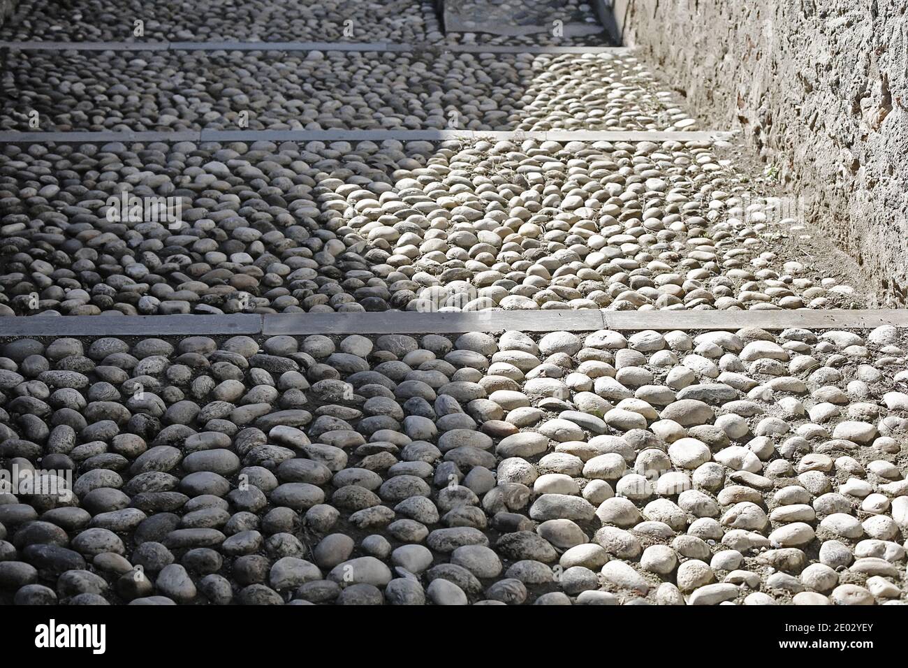 Italian street background pattern with old gray paving road with round ...