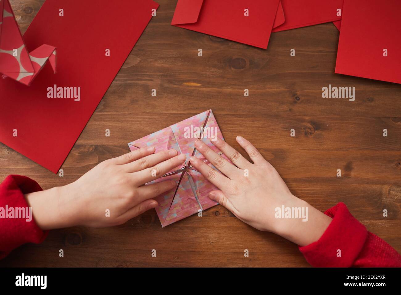 Top-down flat lay shot of little girls hands making origami using ...