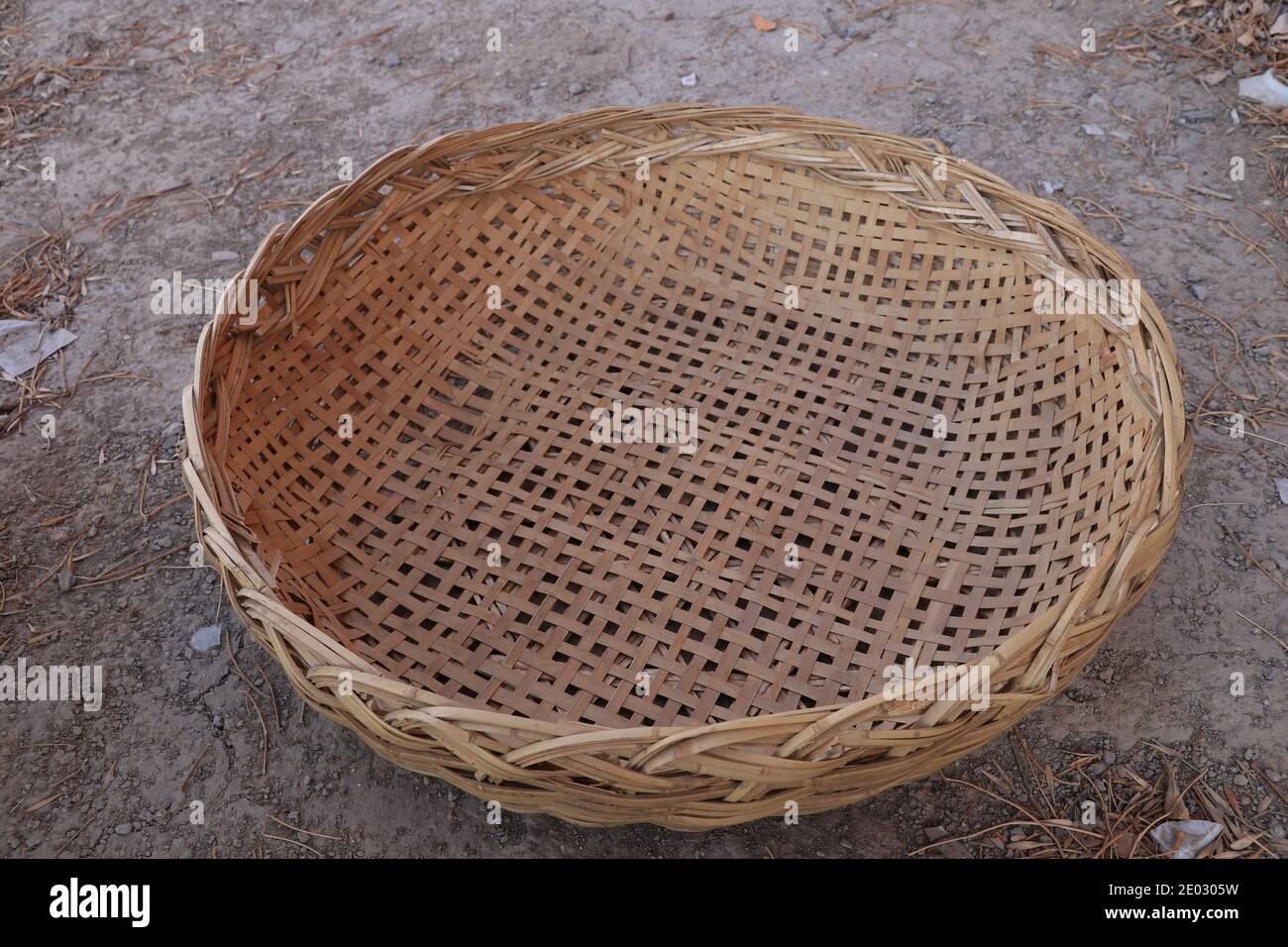 Top view of old threshing basket on rustic muddy ground, woven bamboo ...