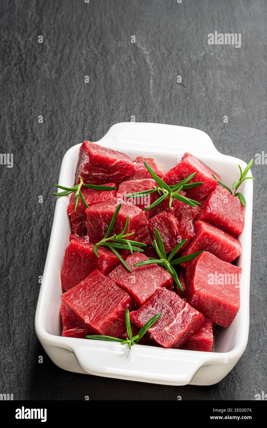 Cubes of raw beef meat on black stone background Stock Photo - Alamy