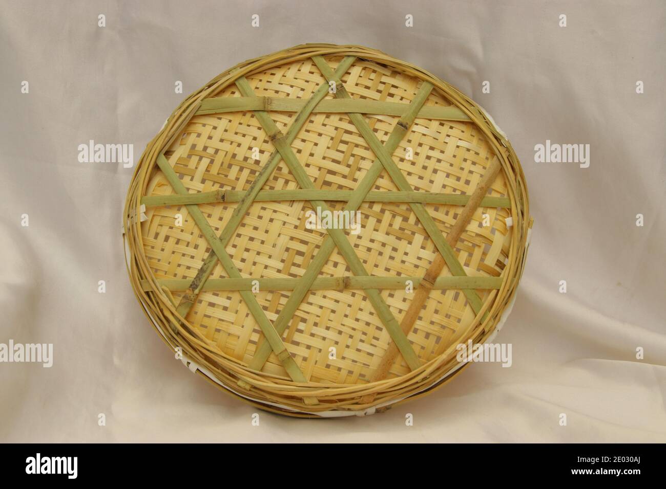 The bottom of a handmade round bamboo sieve. Green woven materials on ...