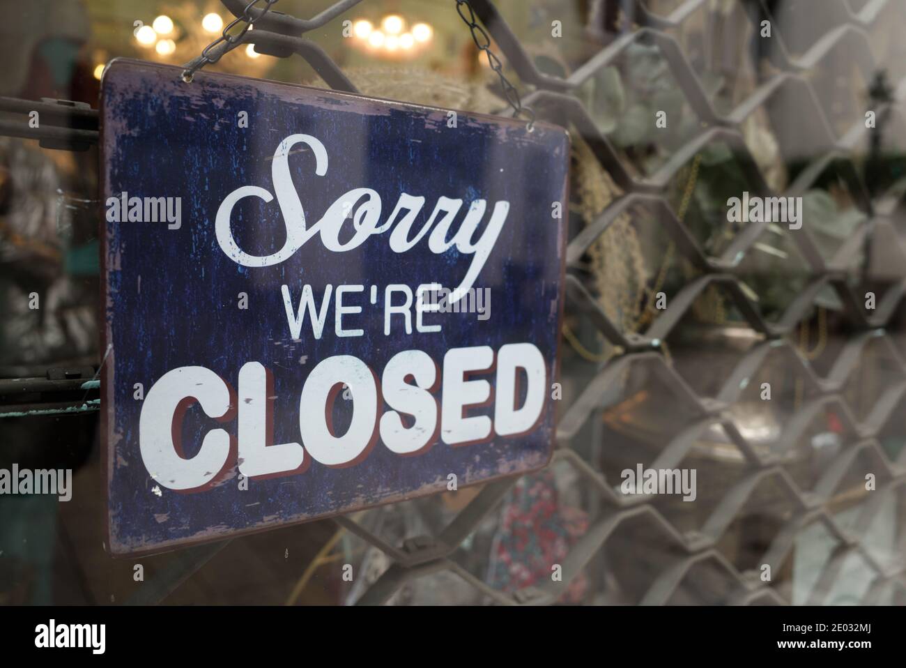 " Sorry we are closed " retro wooden sign is hanged behind glass of ...