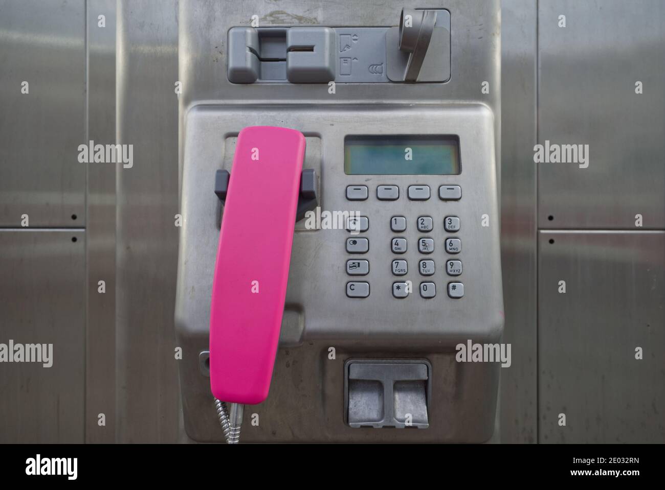 Close-up detail of phone and metal keypad inside public Telephone booth ...