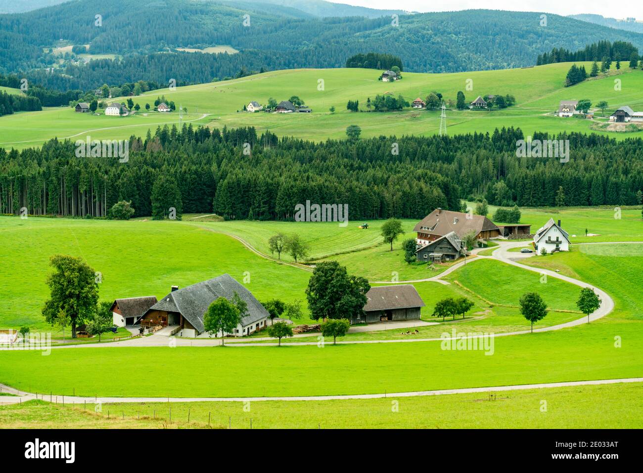 Pleasing landscape of hills, forest, grass, and farm; idyllic scenery ...